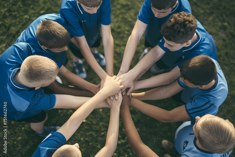 Boys in a sports team stacking hands together and standing in a circle ...
