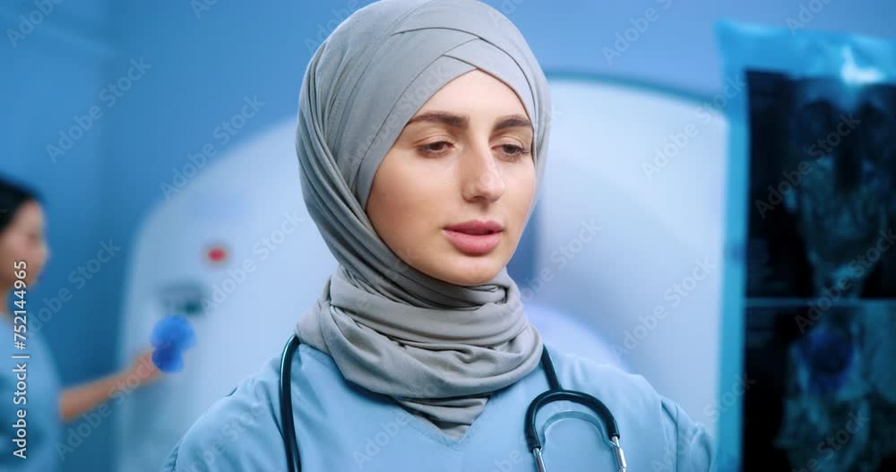 Vidéo Stock Close up Arabian doctor in hijab looking at MRI image ...