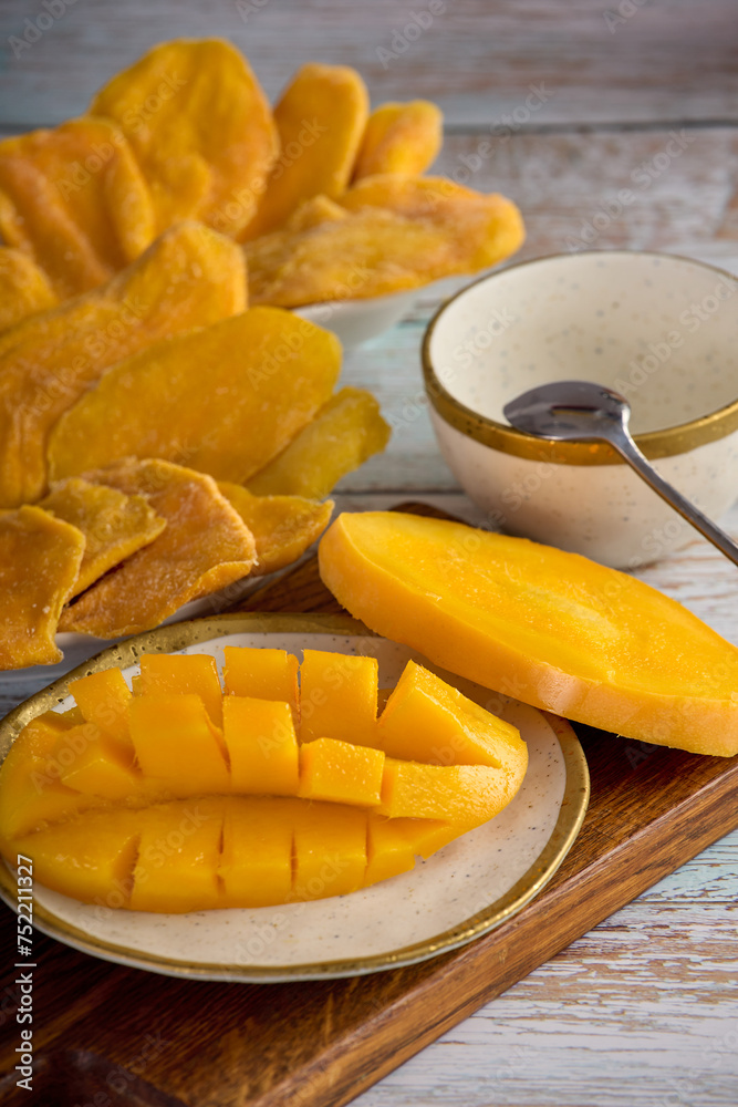 Vertical image Candied mango slices laid out on a plate and chopped ...