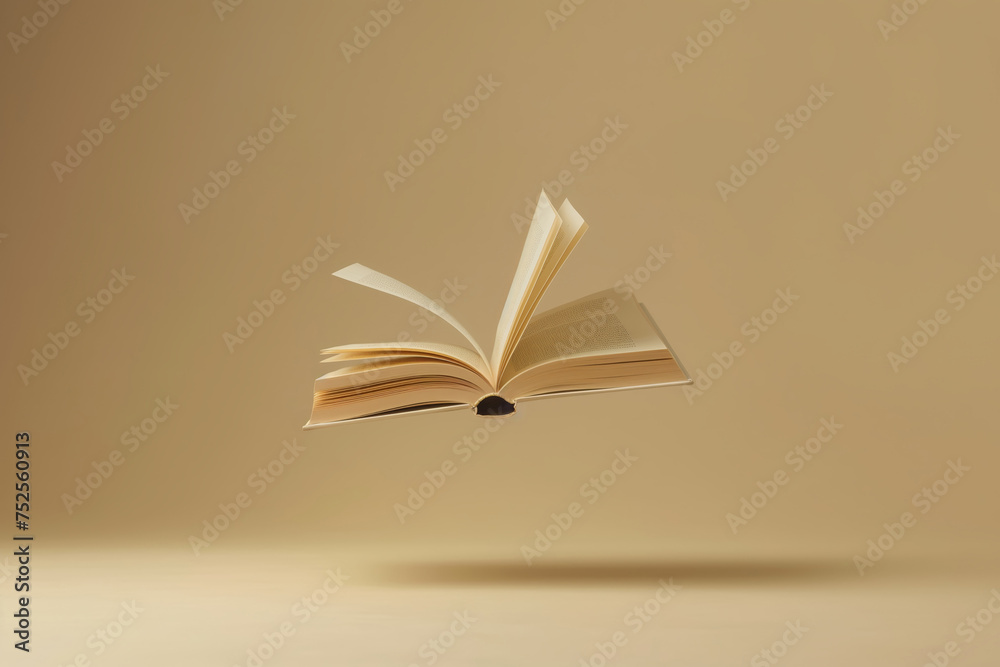 Open book is floating in the air casting a shadow over an beige ...