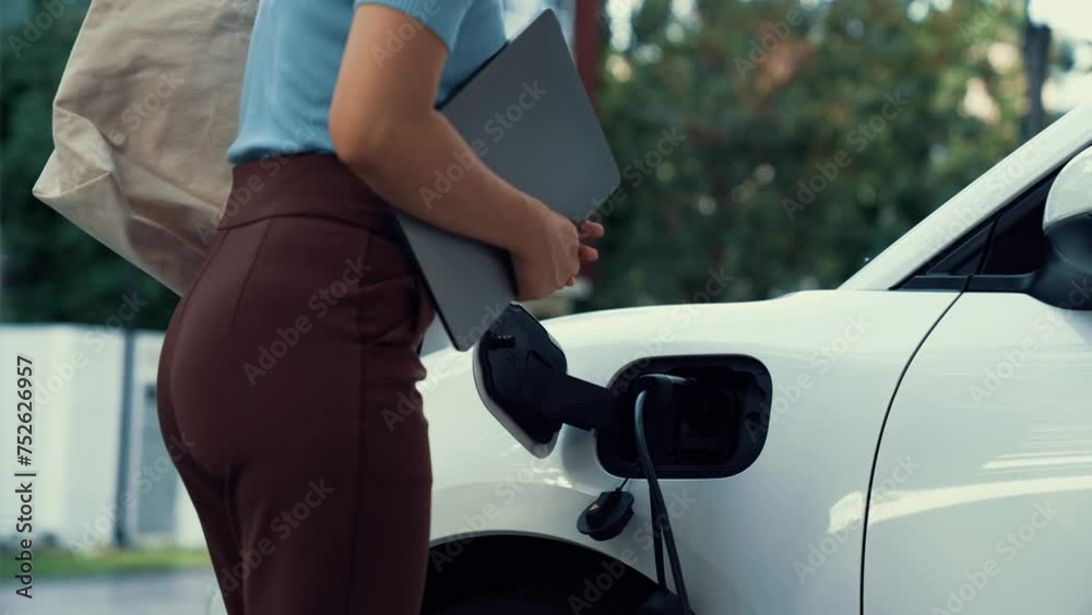 Woman recharge her electric car with EV charger from smart home ...