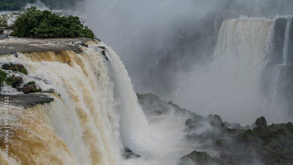 The powerful foaming streams of the waterfall collapse in the gorge ...