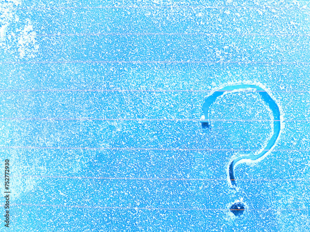A question mark written in the snow. The cold frosty texture of the ...
