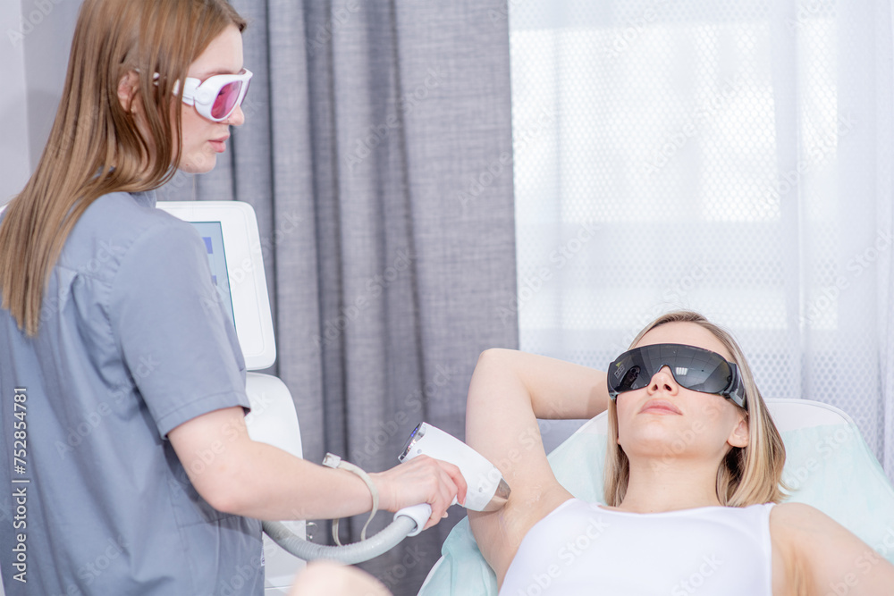 Professional beautician removes hair on armpit using a laser. Armpit ...