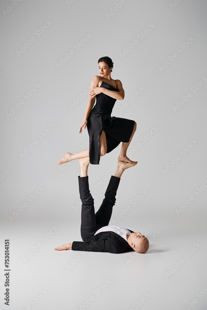 Dynamic duo of two acrobats performing balance act in a studio setting ...