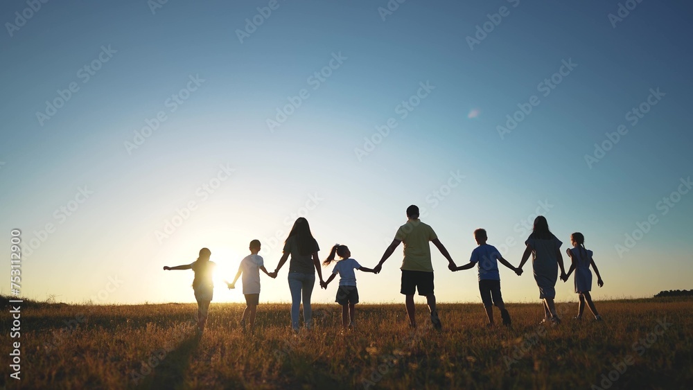 big family. huge community family holding hands walking in the park at ...