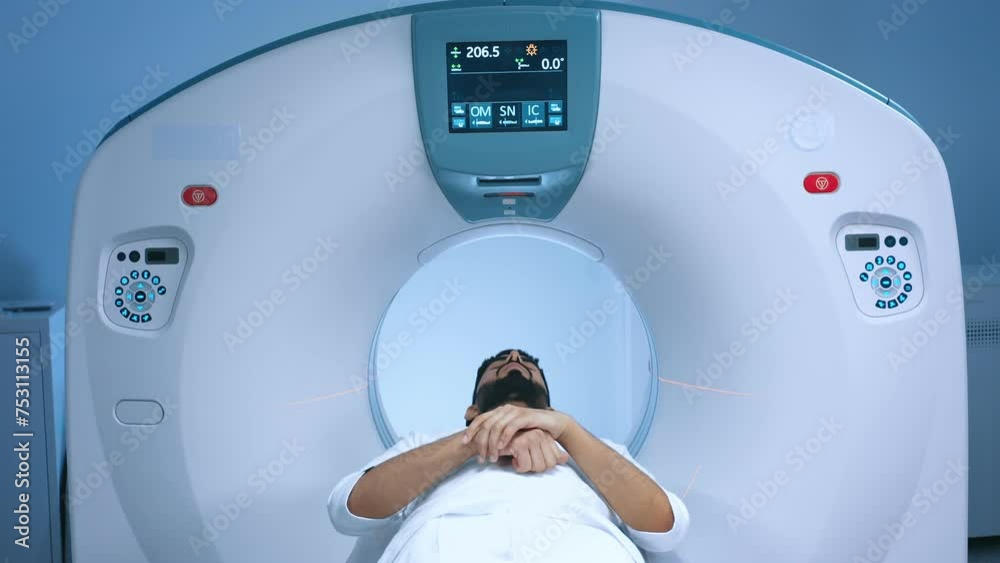 Indian patient undergoing magnetic resonance tomography. View of MRI capsule with lying patient ...