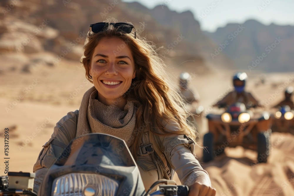 A woman is smiling as she rides a four-wheeler through the arid desert ...