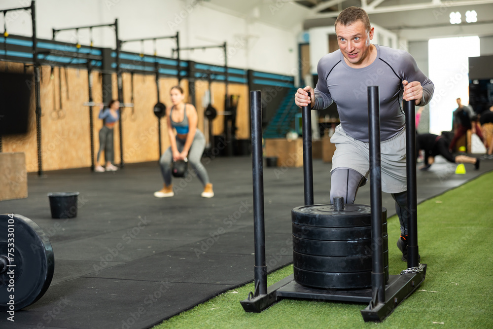 Man during workout with element of push and pull weight metal disks ...