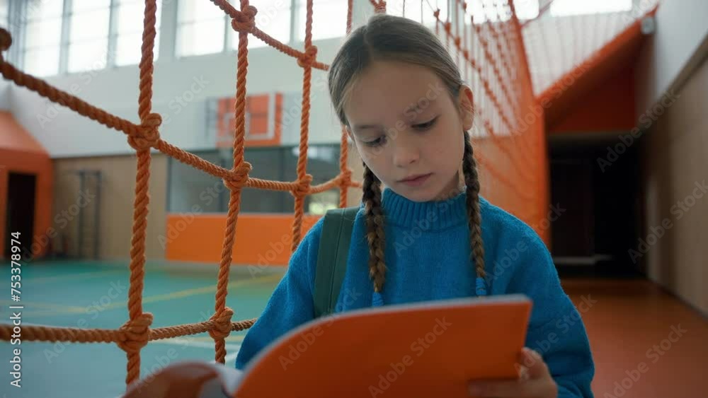 Little girl studying in gym school inside education self-study reading ...