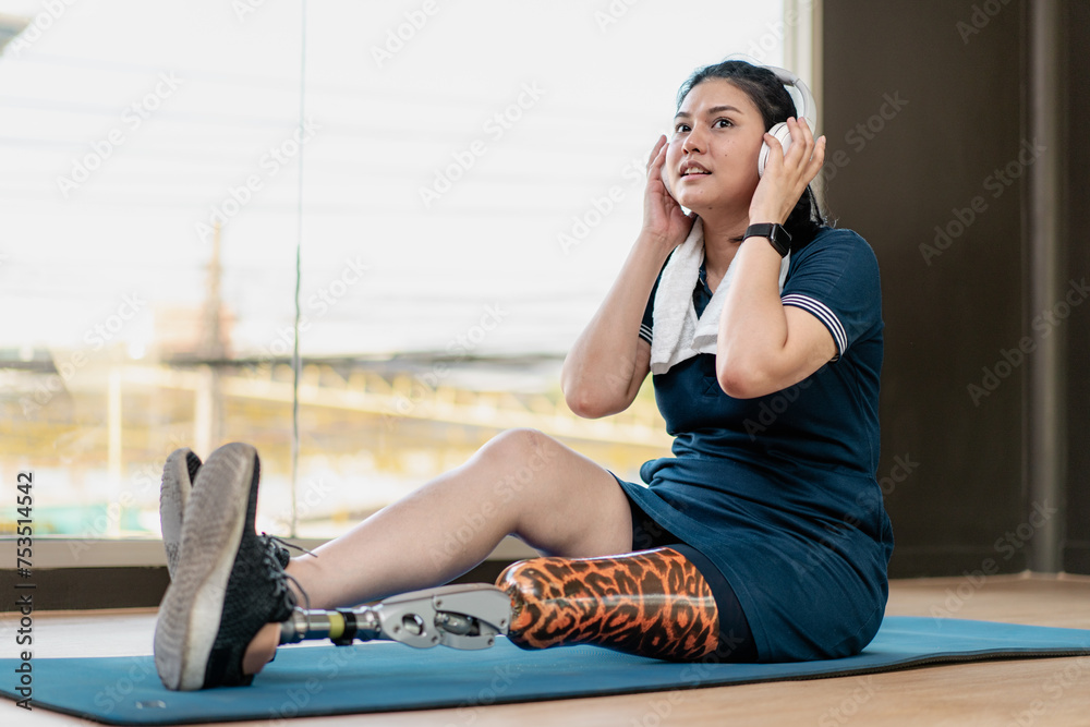 Prosthetic leg amputee woman sit relaxing in gym. Asian female with ...