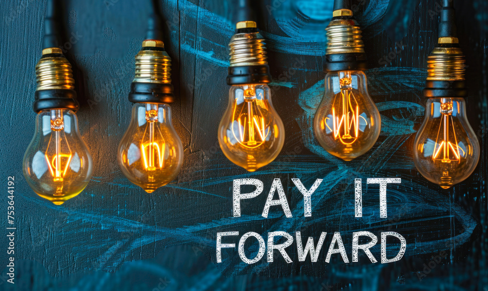 Chalkboard concept with lightbulbs and highlighted PAY IT FORWARD ...