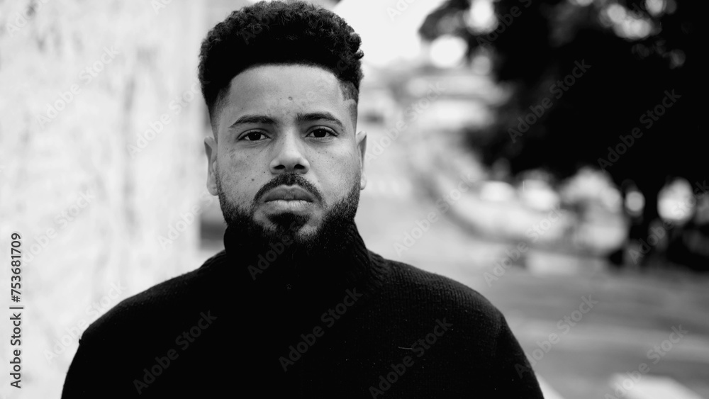 One serious young black man walking forward in urban street with stern ...