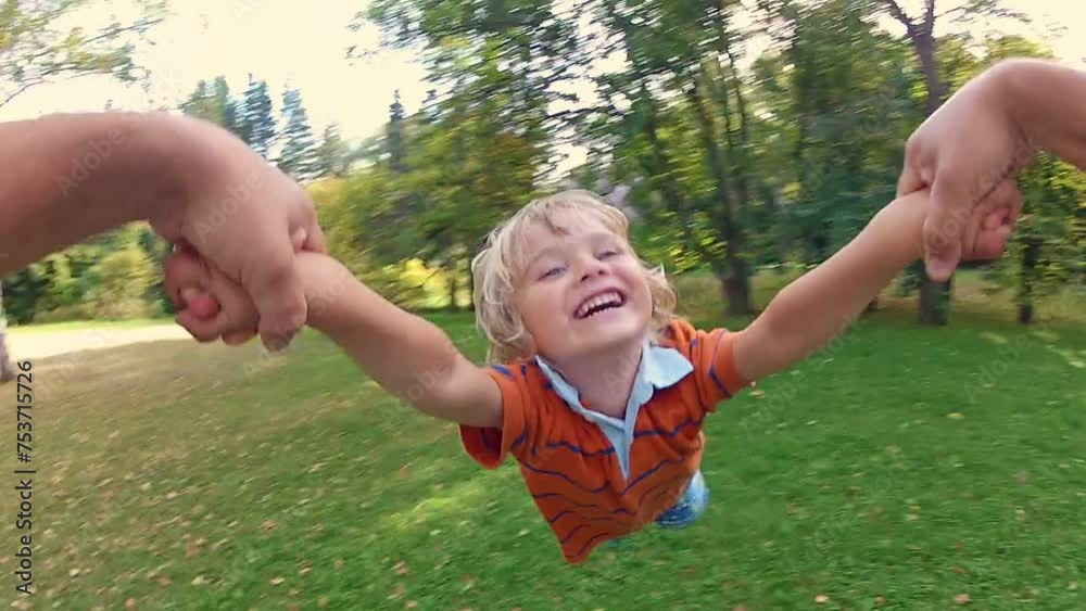 Boy is spinning in a circle by father. View from the hands of the ...