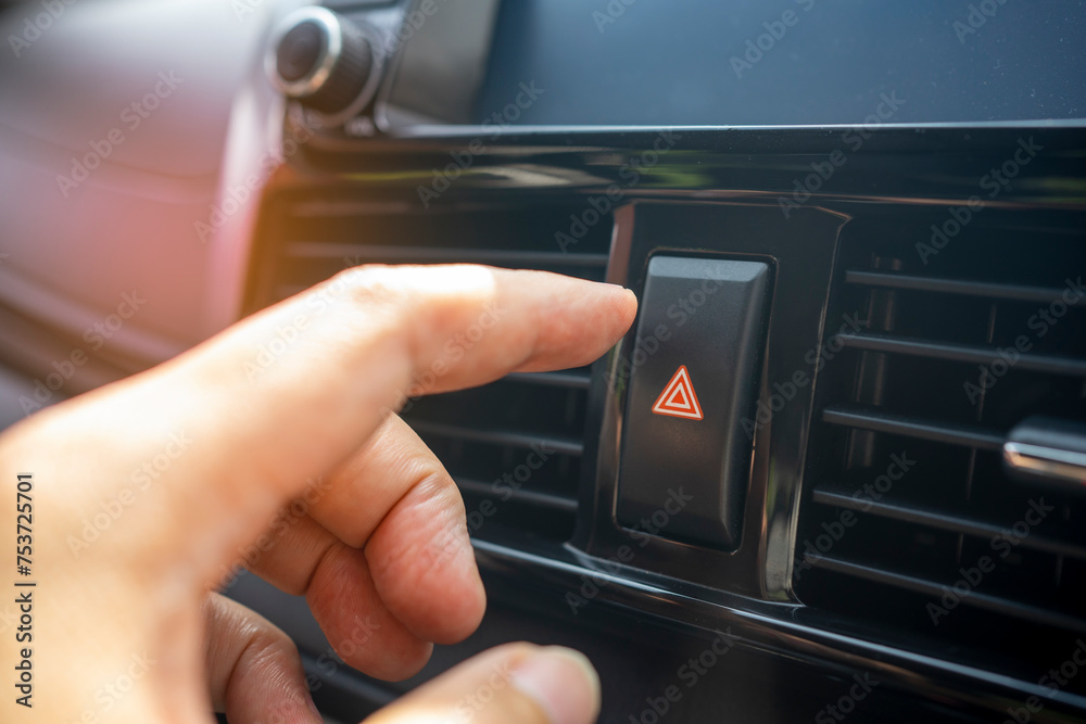 The driver is pressing the emergency stop button on the car dashboard ...