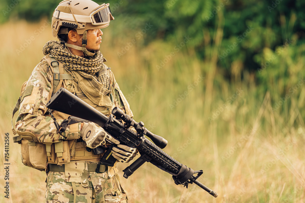 A brave soldier of the army stood looking at the target ahead. Wearing ...