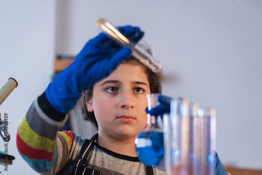 A cool teenager in a home research laboratory wearing safety glasses ...