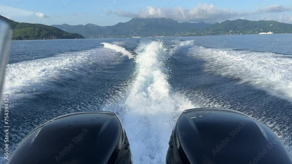 Waves from the engines of a high-speed boat. Rear view. Blue sky, white ...