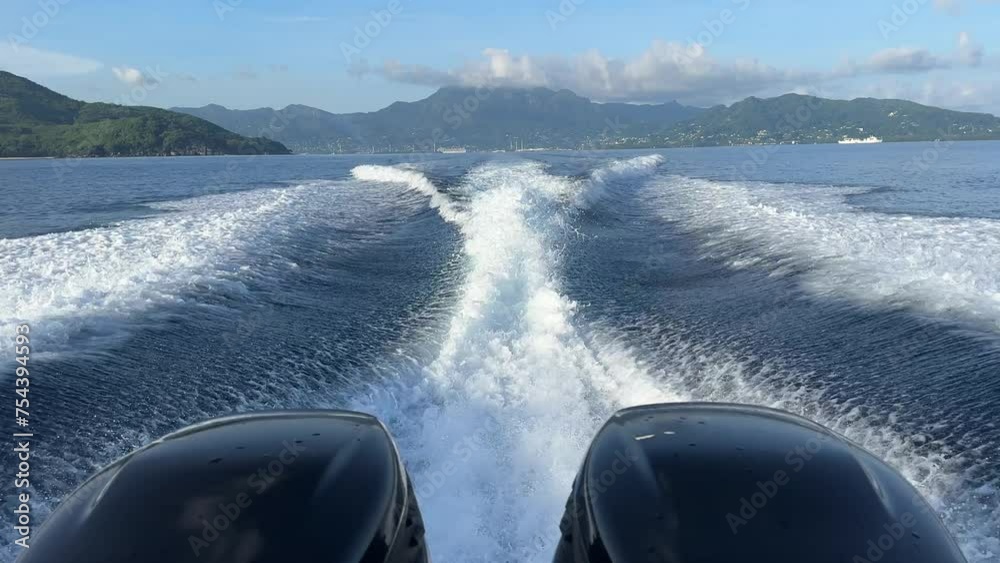 Waves from the engines of a high-speed boat. Rear view. Blue sky, white ...