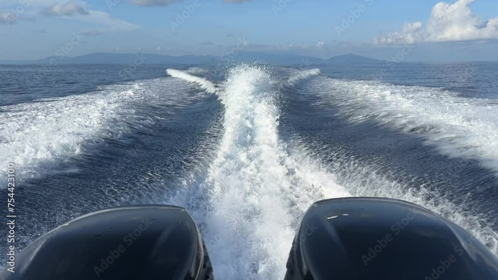 Waves from the engines of a high-speed boat. Rear view. Blue sky, white ...