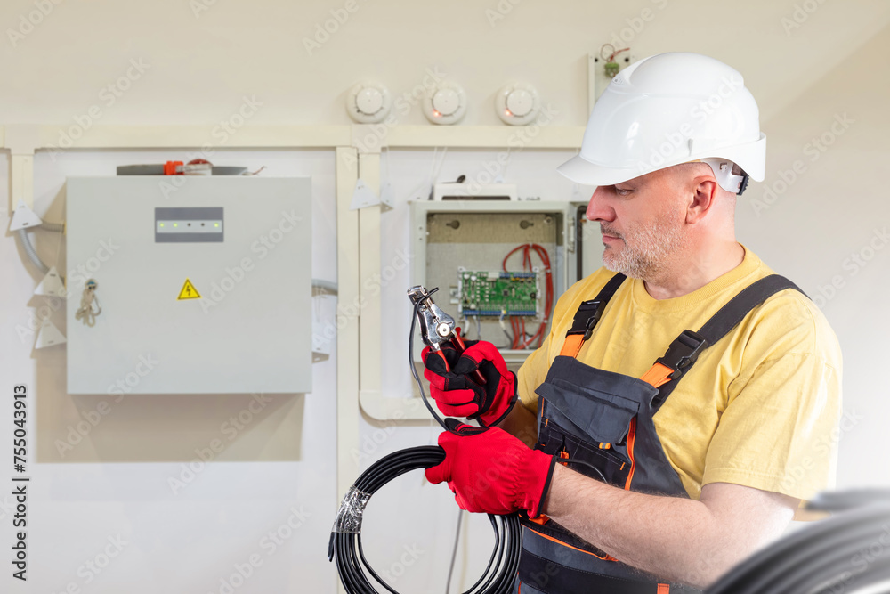 Man is electrician. Repair of power shield. Electrical cabinet is ...