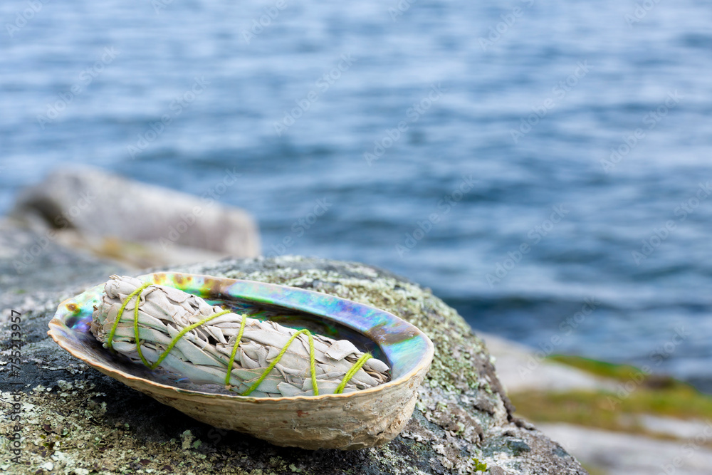 An tranquil image of a white sage smudge stick and abalone sea shell ...