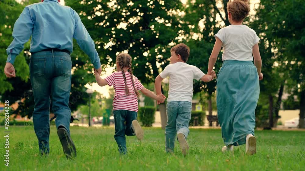 Weekend play, holiday kids, Children and parents run together on green grass. Family game ...