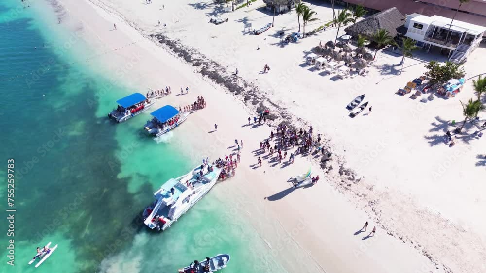 People board a tourist catamaran to embark on a tour of tropical ...
