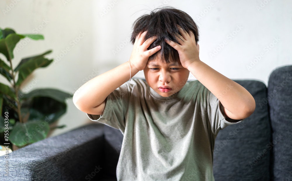 Portrait of sick depressed unhappy child boy touching on head feel ...