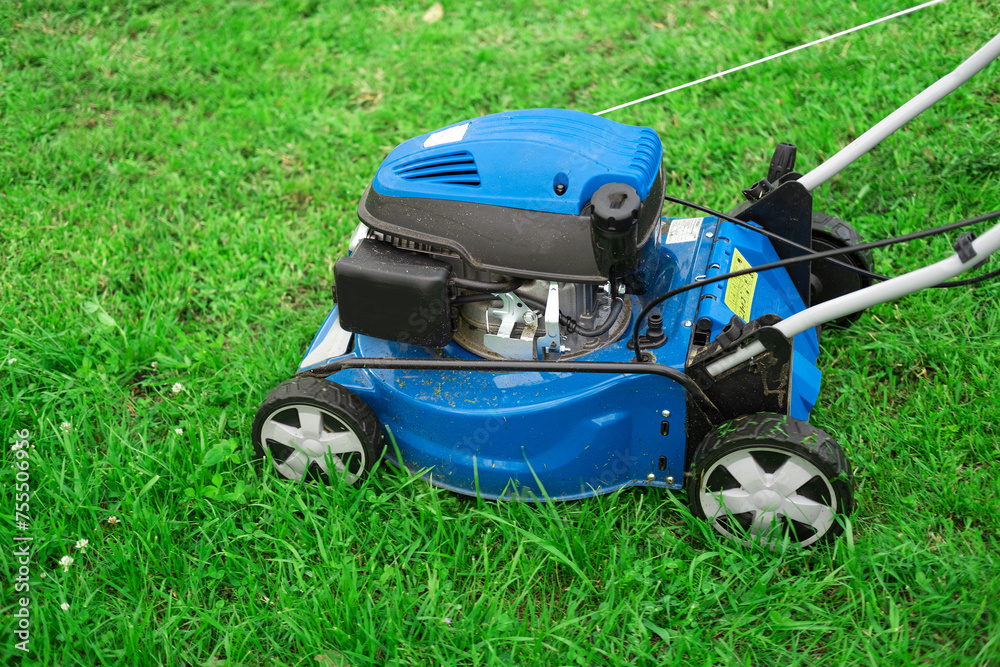 Lawn mower cutting grass. Small grass cuttings fly out of lawnmower ...