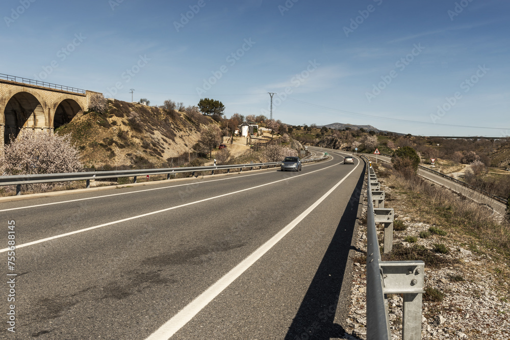 A two-lane road with one lane in each direction with a solid white line ...