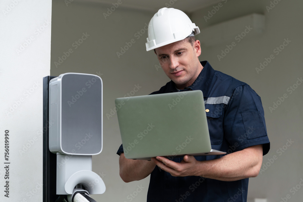 Qualified technician working on home EV charging station installation ...
