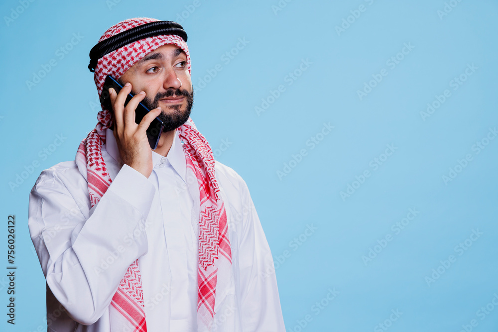 Muslim man dressed in islamic clothes, answering call and having ...
