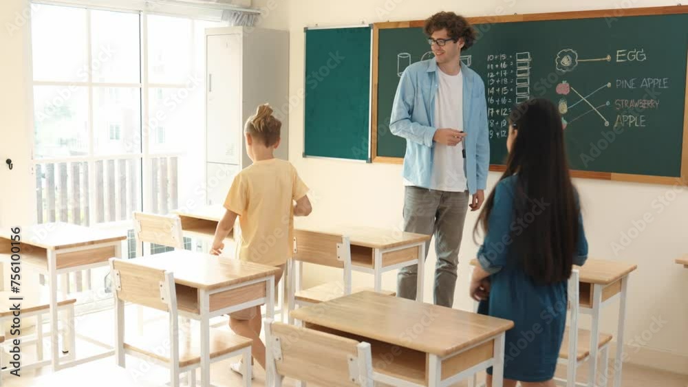 Vidéo Stock Diverse elementary student walking in classroom while ...