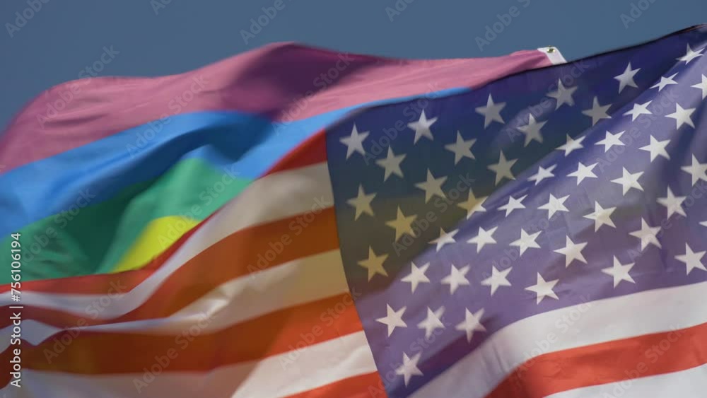 Vidéo Stock The US national flag and rainbow LGBT flag stand tall ...