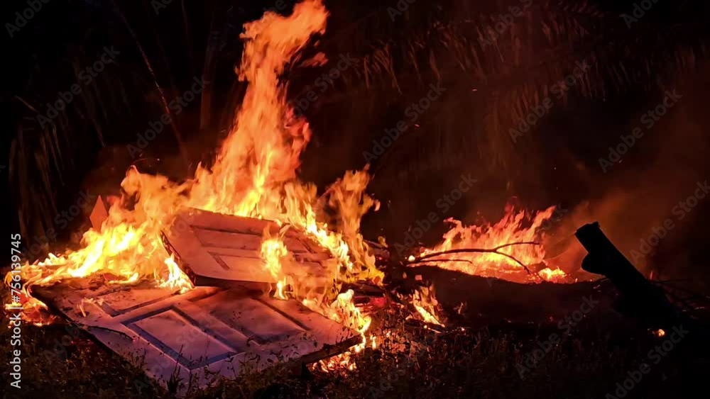 Burning a door and dry branches to the fire. Fire is burning steadily ...