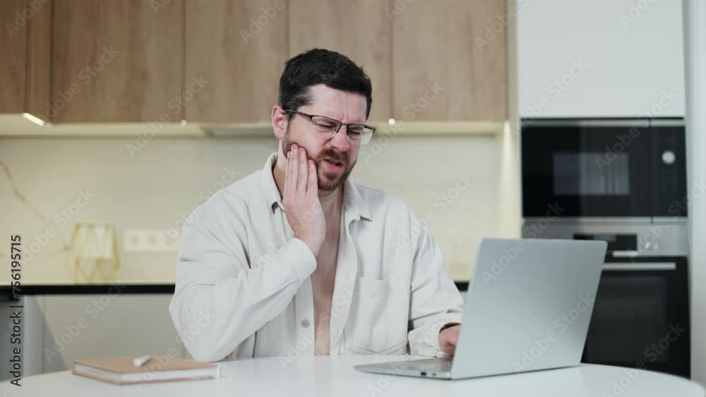 Handsome distant manager with beard touching cheek with hand while ...