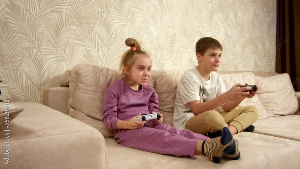Two happy emotional children brother and sister playing game console ...