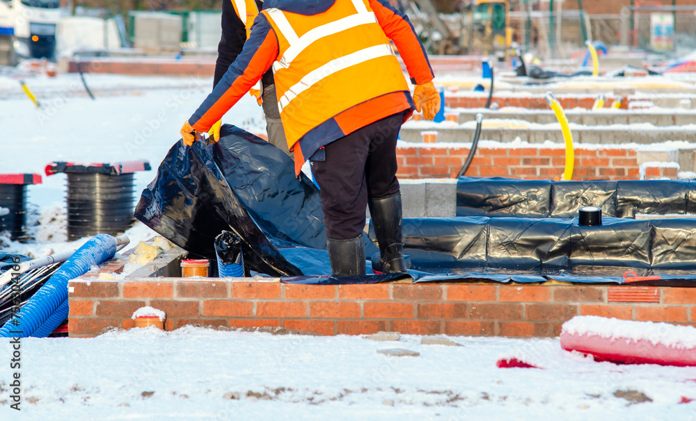 Waterproof installation at new house construction. Builders installing ...