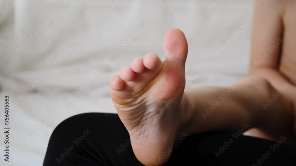 The child shows a thumbs up on his foot. Small tender baby sole close ...