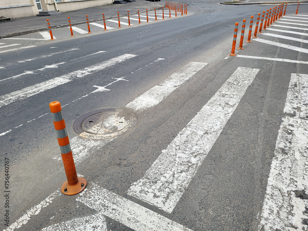 Orange plastic poles, no parking zone. Traffic delineators on roadside ...