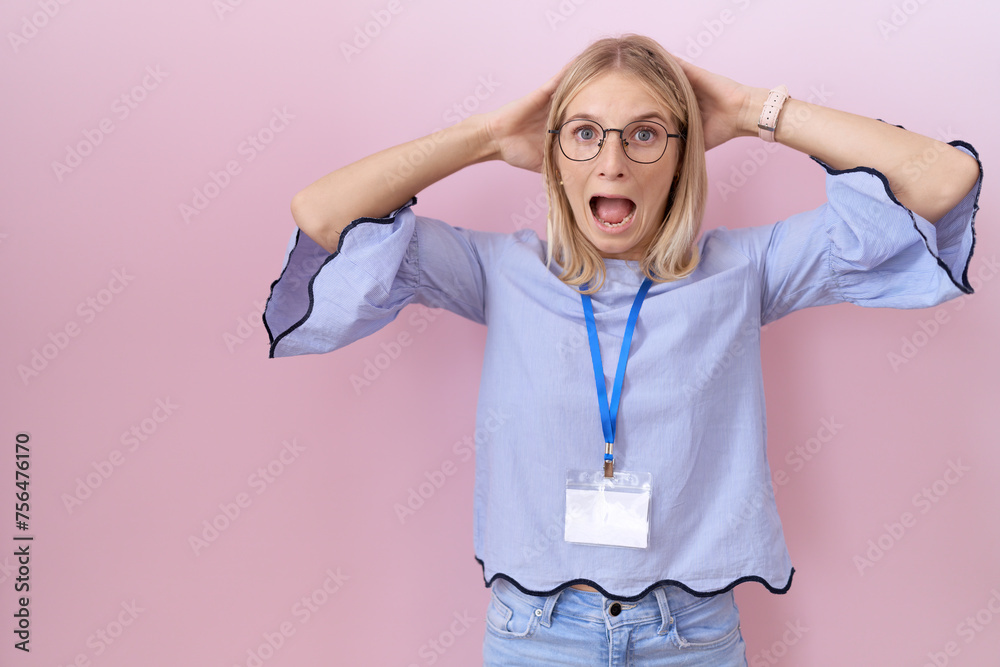 Young caucasian business woman wearing id card crazy and scared with ...