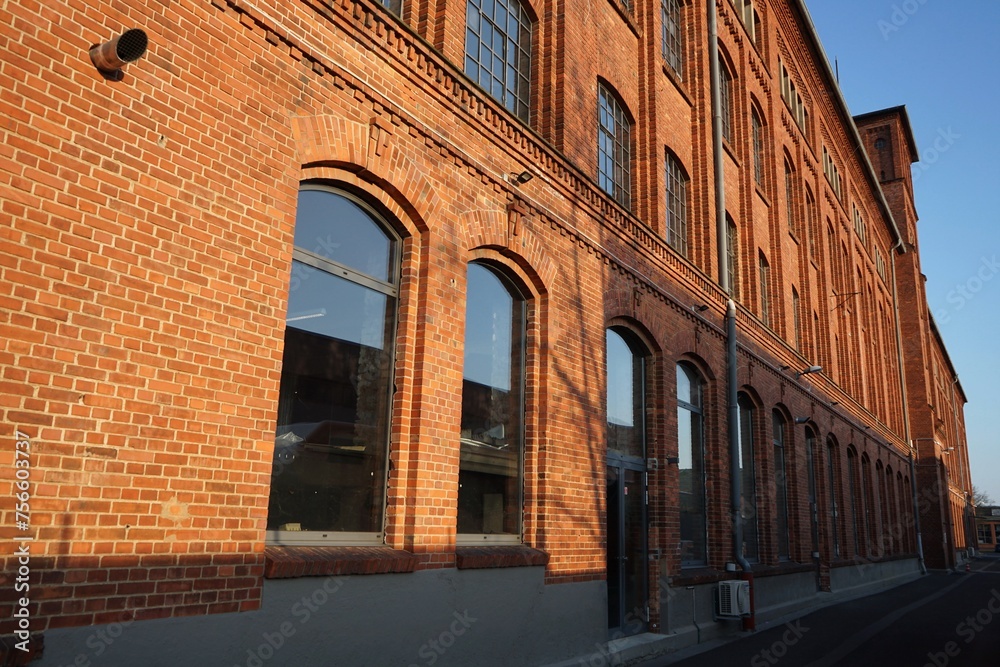 Fensterfront einer alten Fabrik mit Fassade aus Backstein vor blauem ...