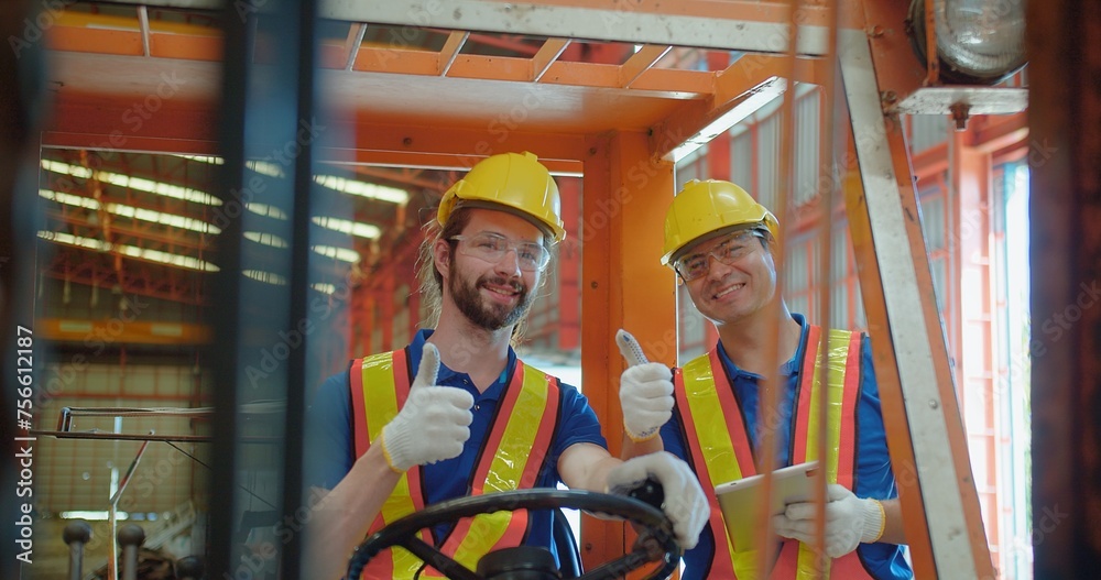 Smiling construction workers in a forklift, giving thumbs up, with one ...