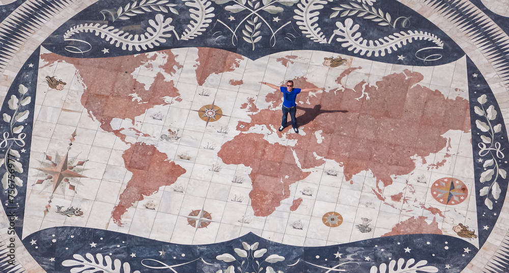 Aerial view of tourist man standing on the giant mosaic of a world map ...