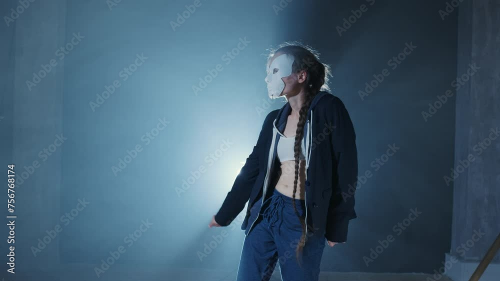 Vidéo Stock Fit girl in face mask dancing contemporary against blue ...