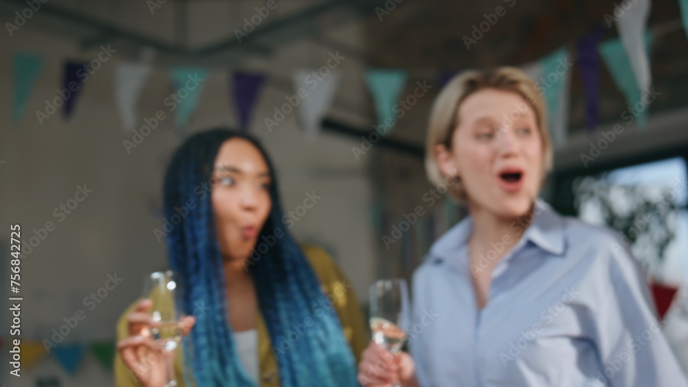 Playful coworkers riding chair at office party close up. Funny happy ...