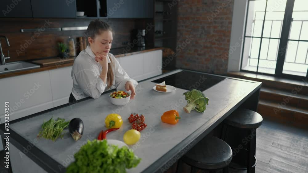 Young woman choose healthy food on diet. Obese girl chooses between a sandwich cheeseburger and ...