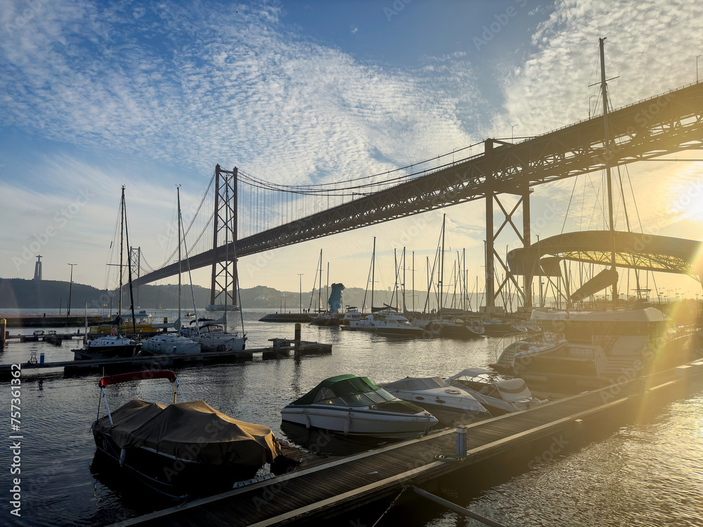 Lisbon docks with boats and views of the 25 de Abril bridge. With ...
