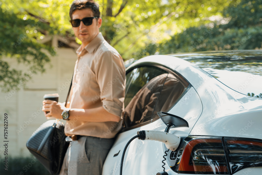 Eco friendly man and sustainable urban commute with EV electric car ...